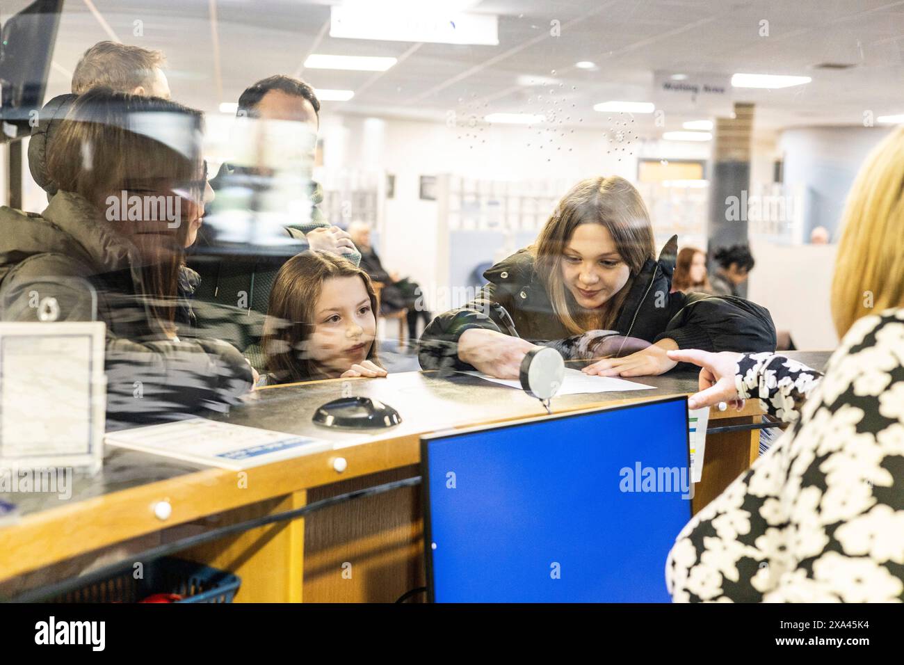 Child and adult at a service counter Stock Photo - Alamy