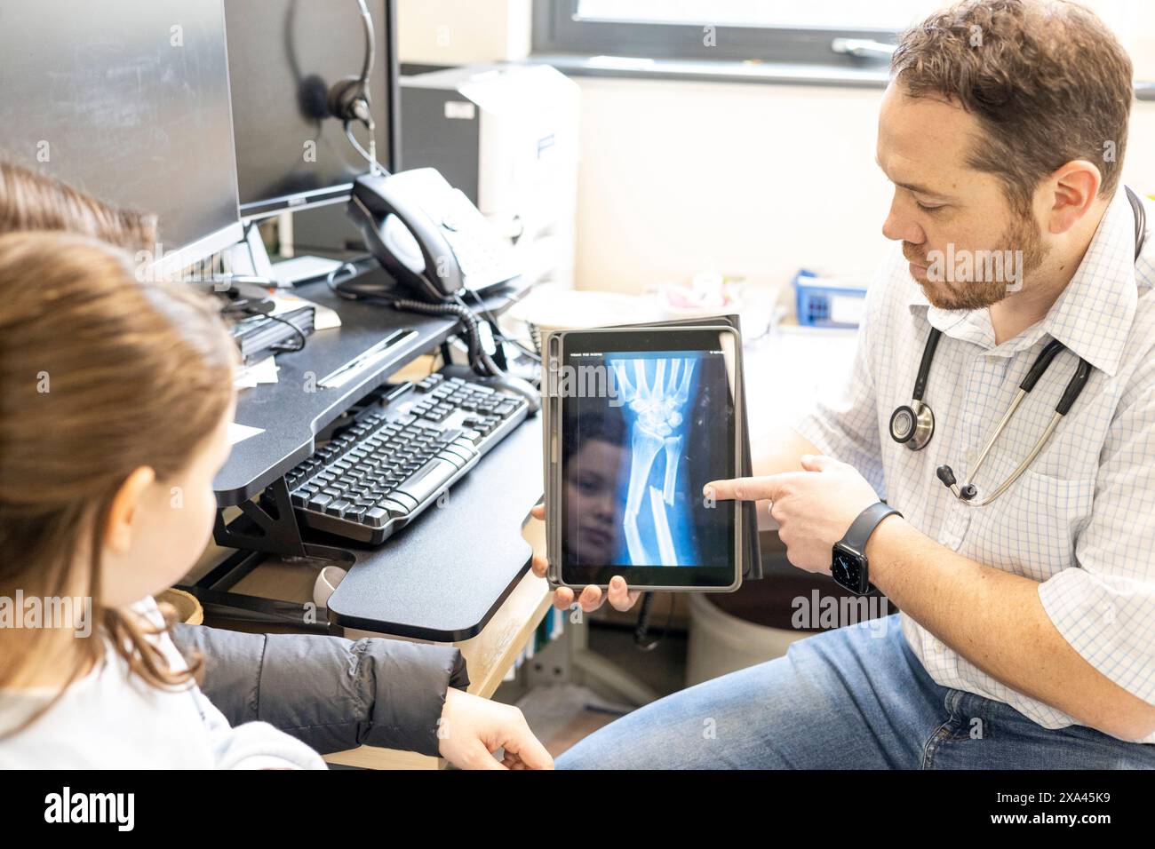Doctor showing X-ray to a child on a tablet Stock Photo - Alamy