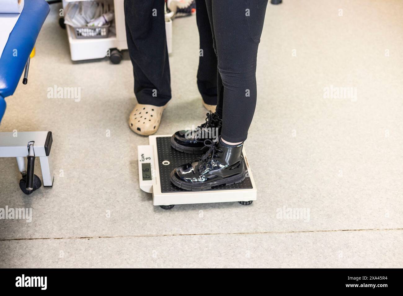 Person standing on a scale in a medical practice Stock Photo - Alamy