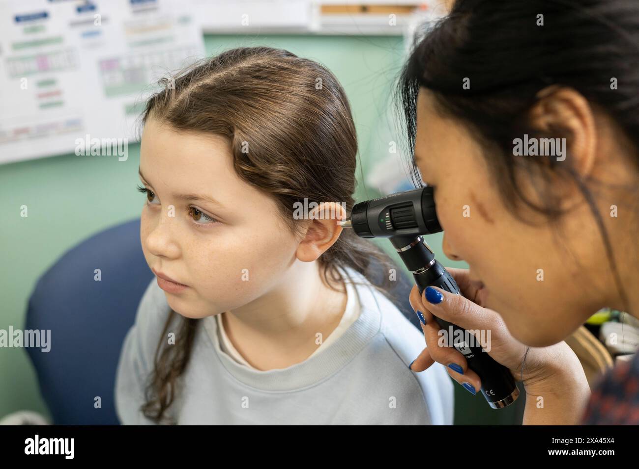 Doctor performing an ear examination on a young girl Stock Photo - Alamy