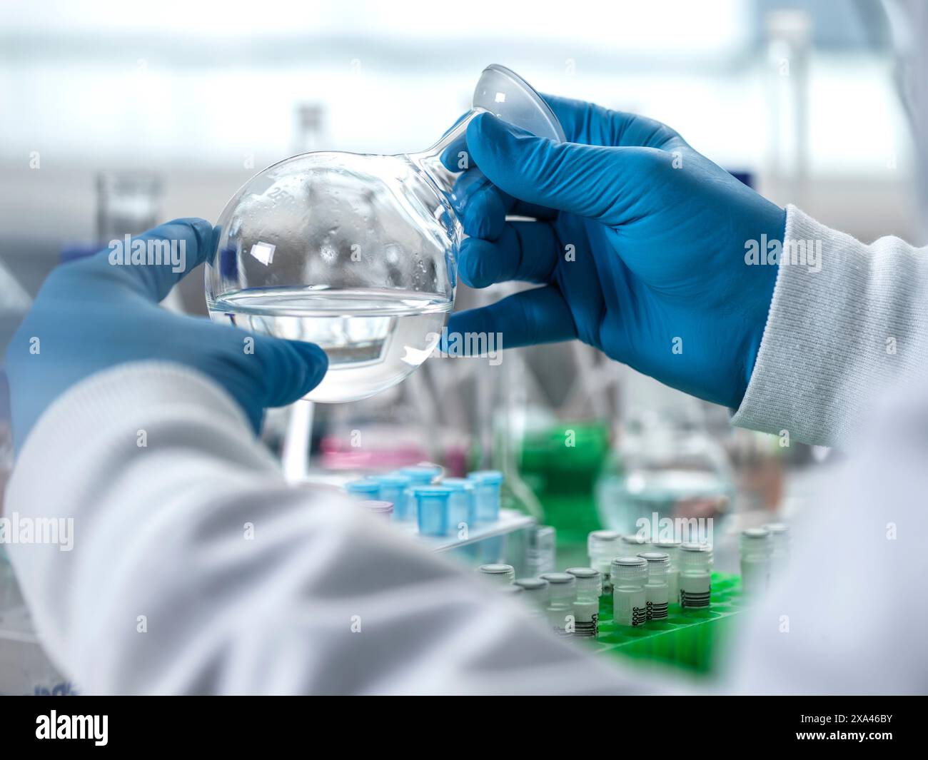 Scientist pouring liquid into a flask in a laboratory Stock Photo - Alamy