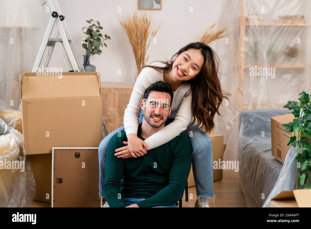 Couple embracing amid moving boxes in new home Stock Photo - Alamy