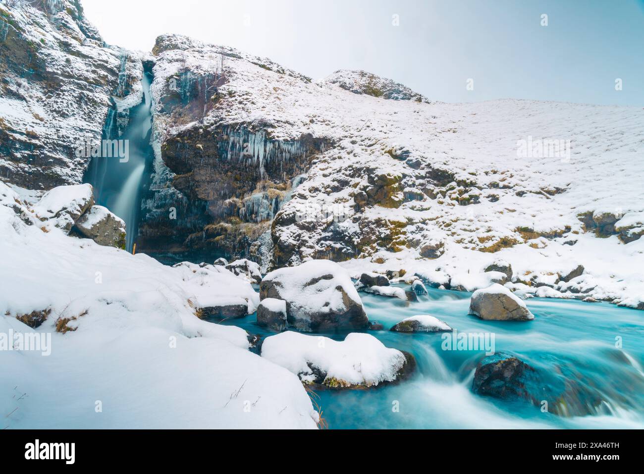 Snowy waterfall with vibrant blue river Stock Photo - Alamy