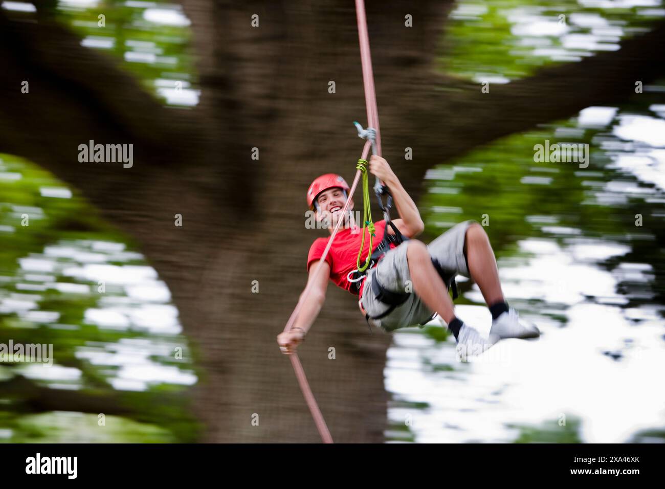 Man dangling from a rope suspended mid air Stock Photo - Alamy