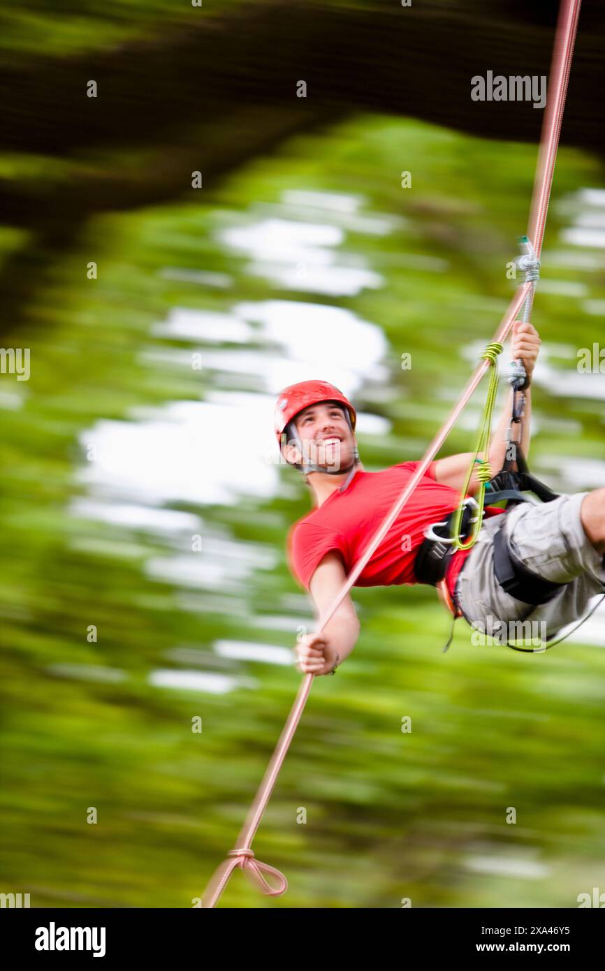 Man dangling from a rope suspended mid air Stock Photo - Alamy