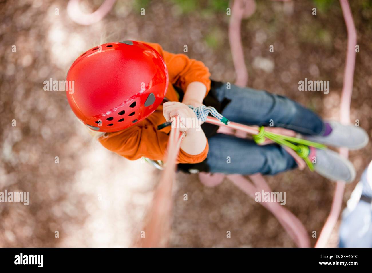 Climber dangling from a rope - high angle Stock Photo - Alamy