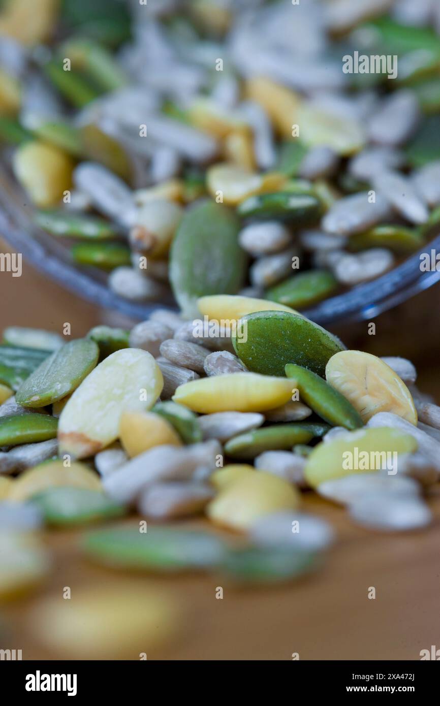 Close up of mixed seeds spilling out of a container Stock Photo - Alamy
