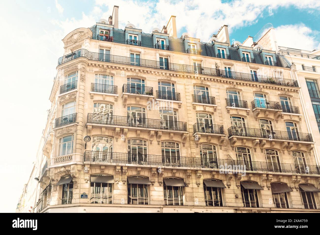 Elegant European building with balconies and attics under a blue sky ...