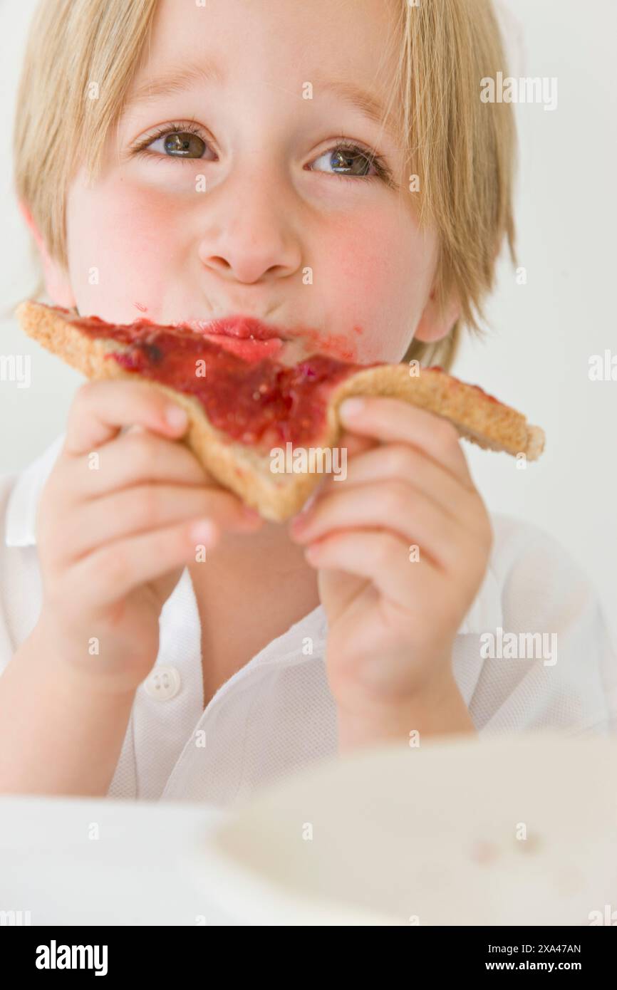 Boy Eating Jam on Toast Stock Photo - Alamy