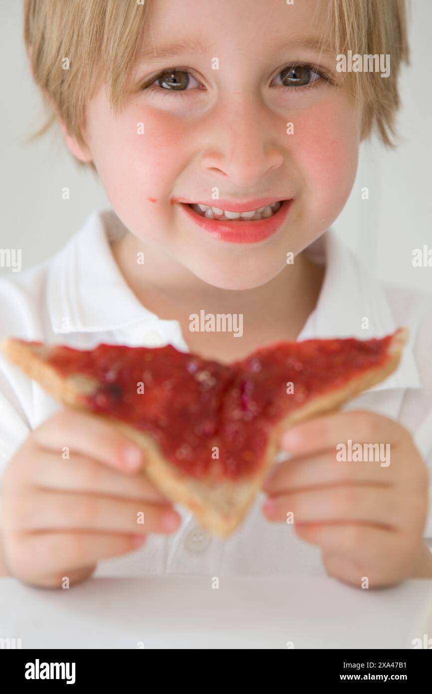 Boy Eating Jam on Toast Stock Photo - Alamy