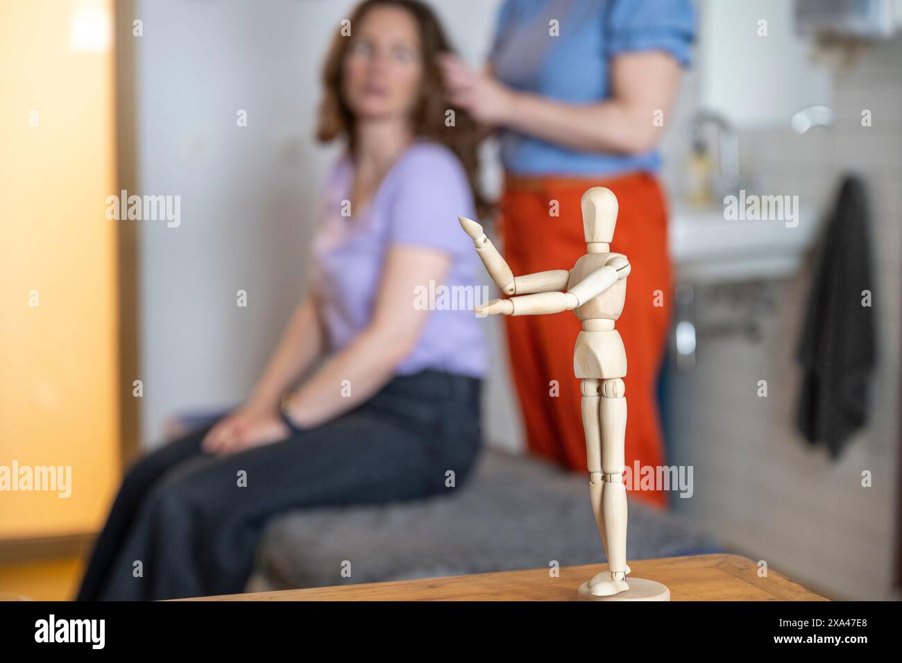 Mannequin figure in focus with hairstyling session in the background ...