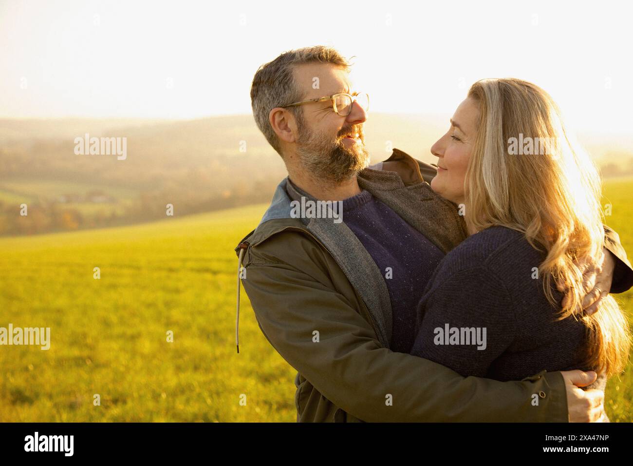 Couple Hugging in a Field Stock Photo - Alamy