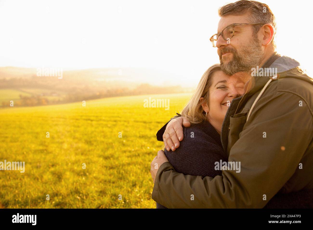 Couple Hugging in a Field Stock Photo - Alamy