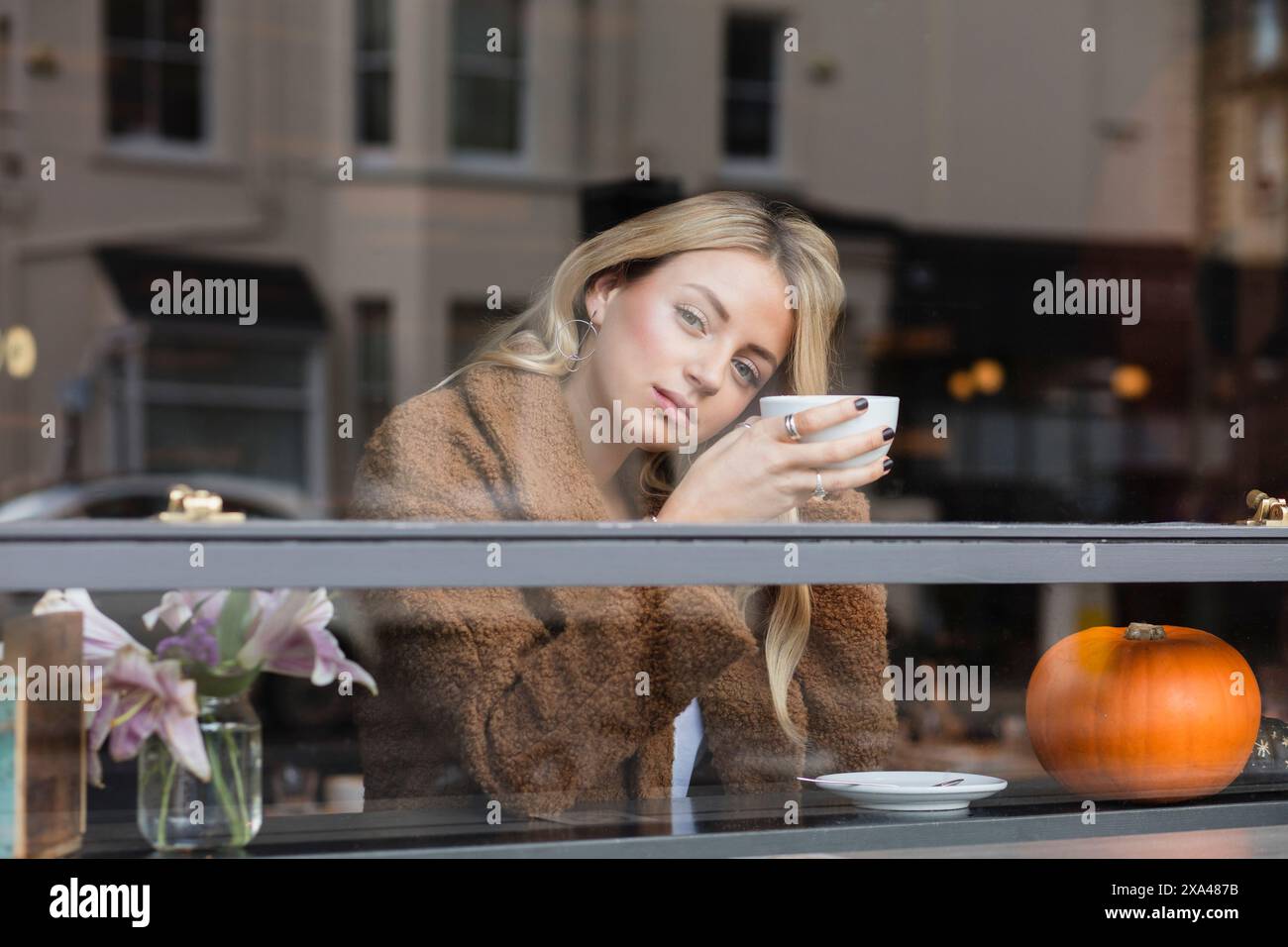 Young Woman Sitting in Cafe Having Coffee Stock Photo - Alamy