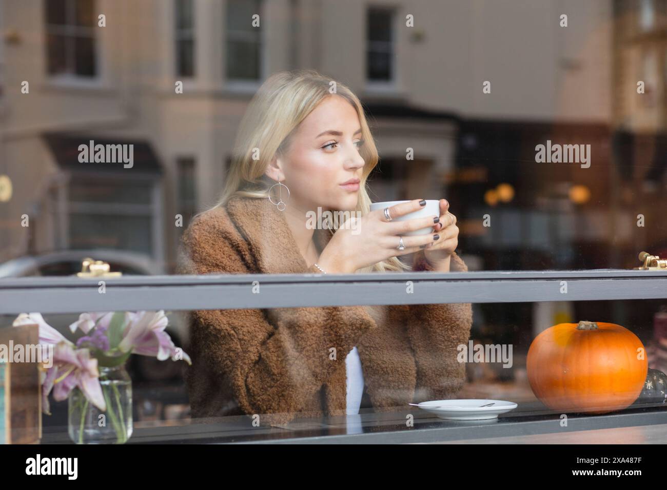 Young Woman Sitting in Cafe Having Coffee Stock Photo - Alamy