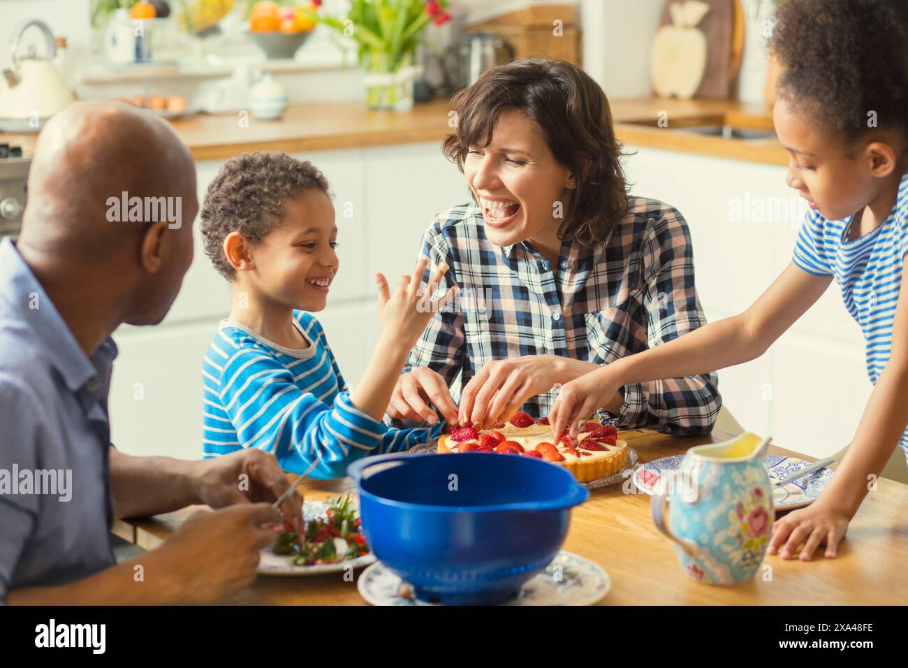 Happy Family around Kitchen Table Stock Photo - Alamy