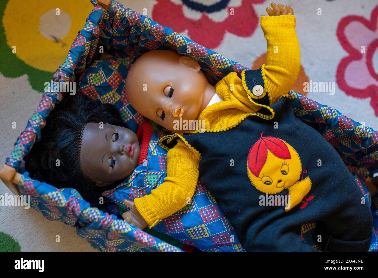 Two dolls lying in a child's playpen Stock Photo - Alamy