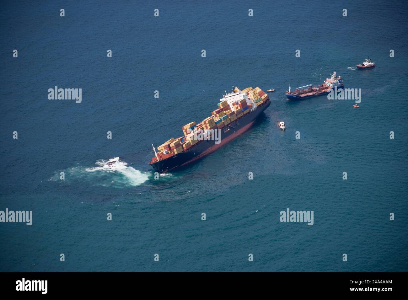 An aerial view of a large cargo ship in trouble at sea, being ...