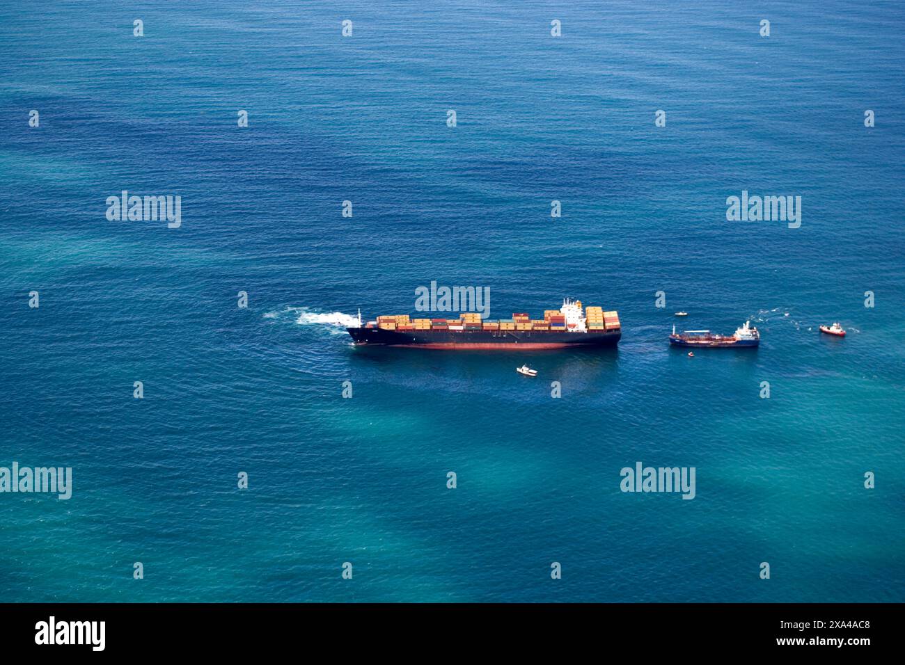 An aerial view of a large cargo ship in trouble at sea, being ...