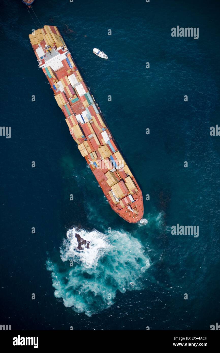 An aerial view of a large cargo ship in trouble at sea, being ...