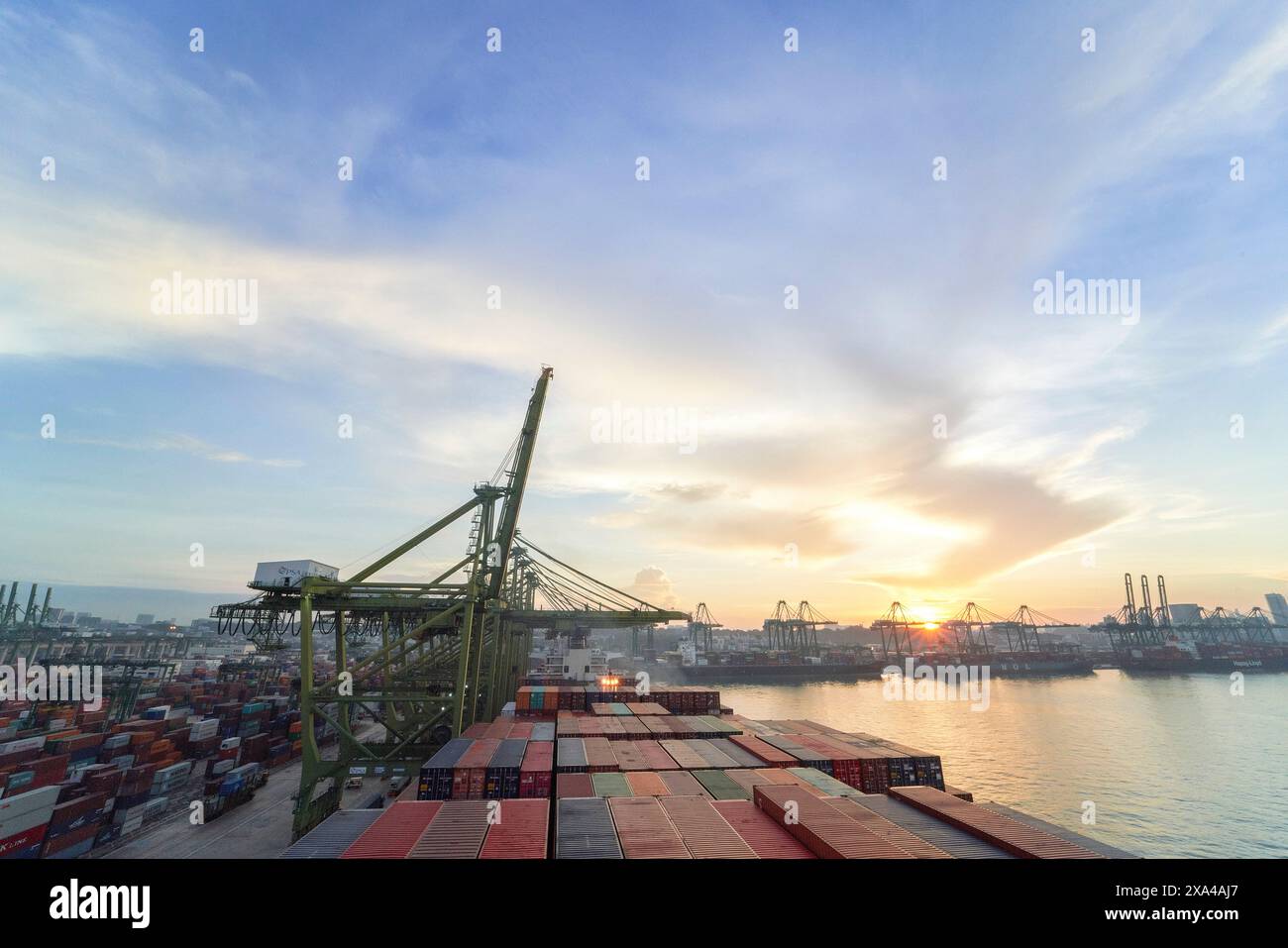 Sunrise view over a busy cargo port with colorful shipping containers ...