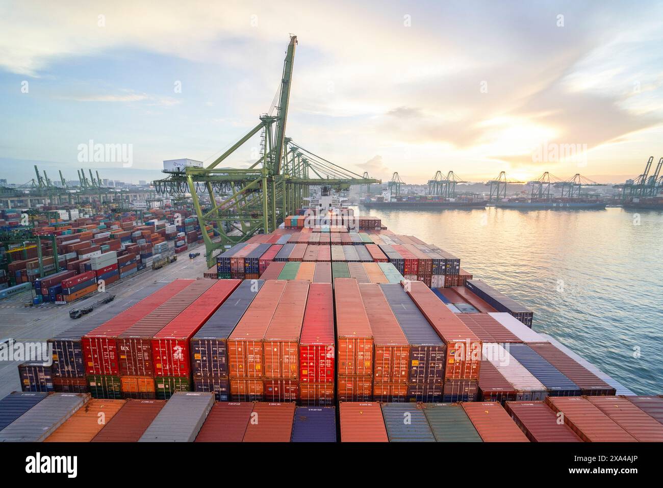 A birds-eye view of a cargo ship loaded with colorful containers docked at a busy port during ...