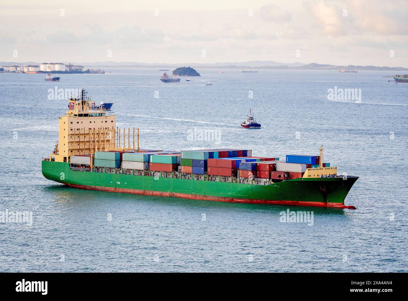 A cargo ship loaded with colorful containers sails through a vast sea ...