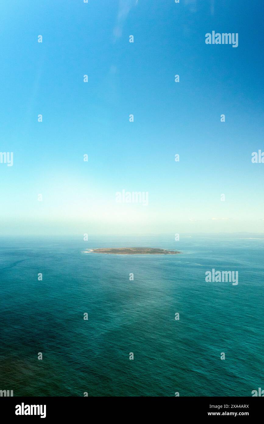 An aerial view of a small, solitary island surrounded by the blue ...