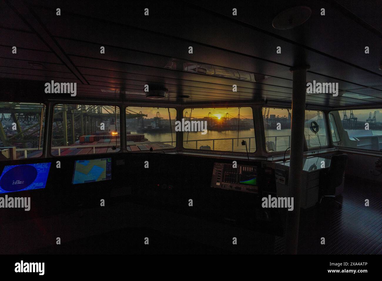 Sunrise viewed through the window of a ship's bridge with navigational ...