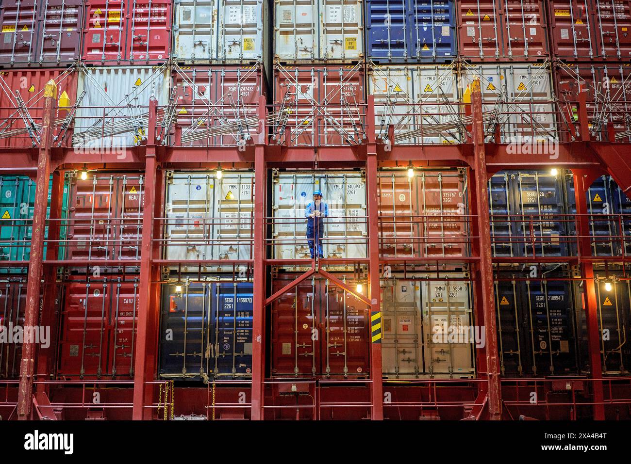 Metal stairway amidst large stack colorful shipping containers night hi ...