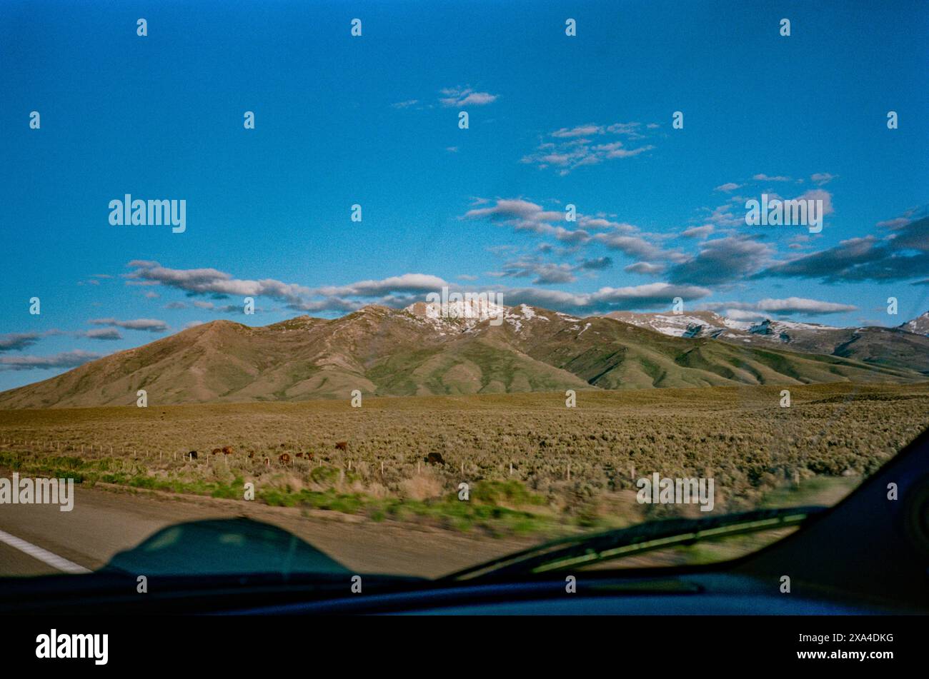 A scenic view from inside a car showing a vast landscape with a ...