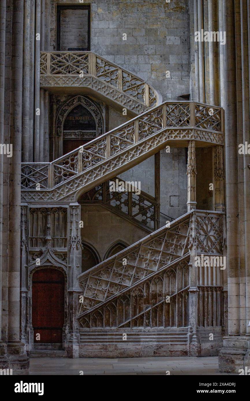 An elegant stone spiral staircase with intricate railing designs inside ...