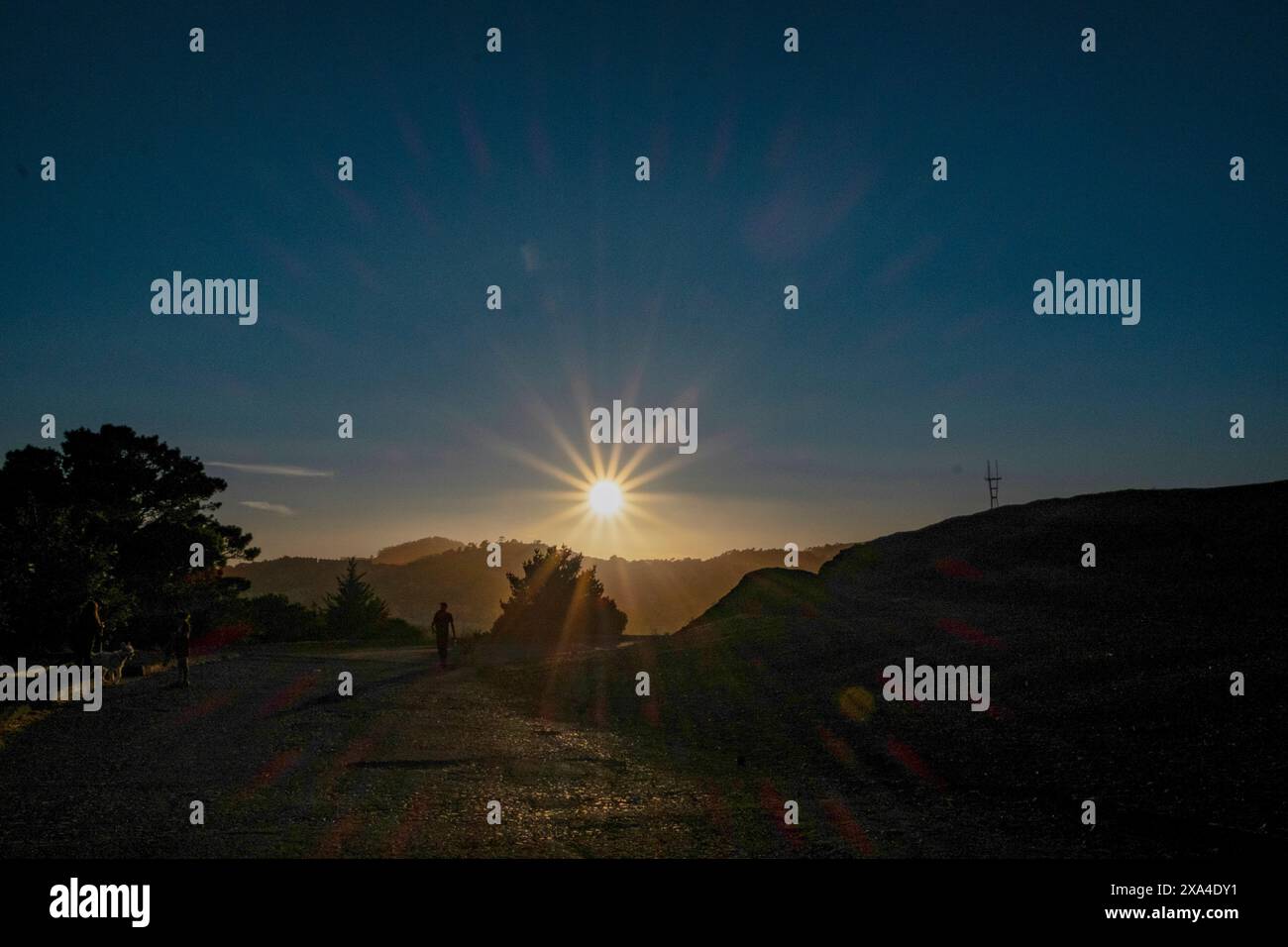 The image features a stunning sunset with the sun's rays piercing ...