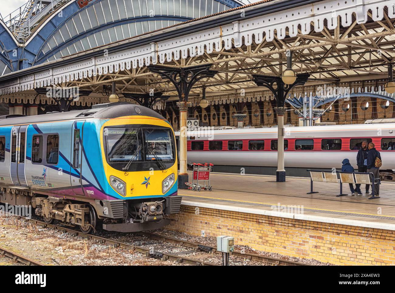 A train sits beside a historic 19th Century railway station platform ...