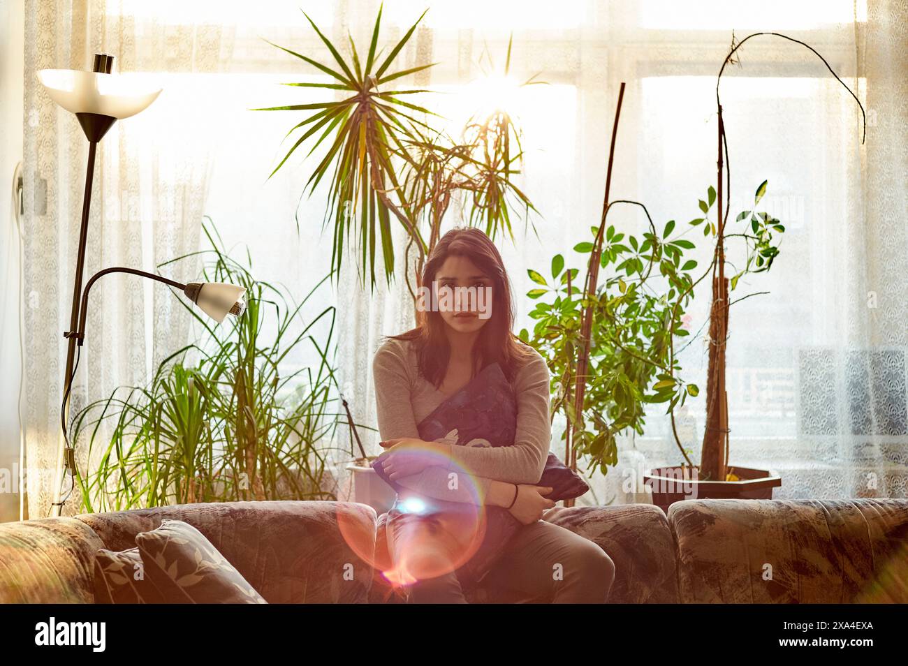 Sunlight filtering through window behind her hi-res stock photography ...