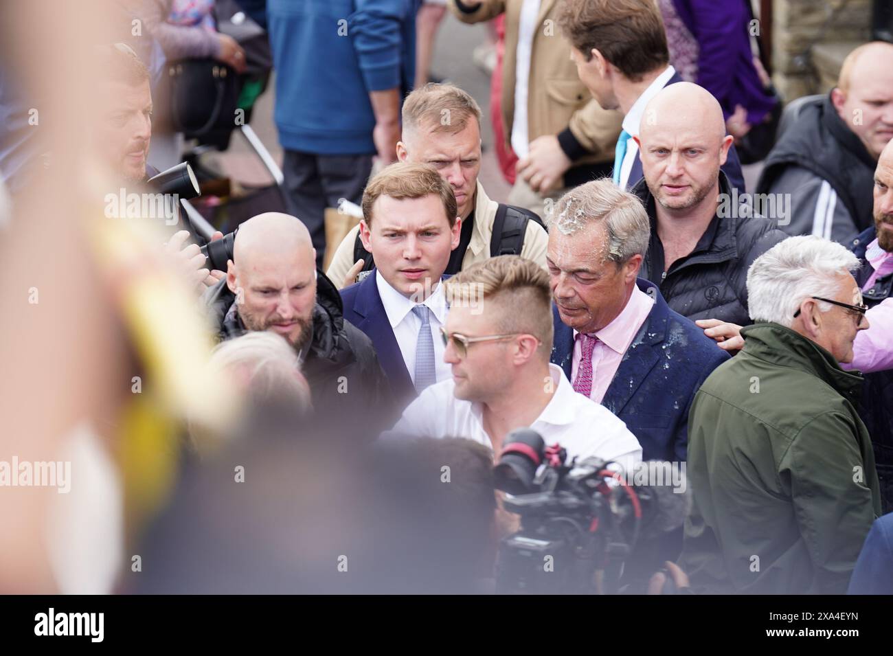 Leader of Reform UK Nigel Farage has a drink thrown over him as he ...