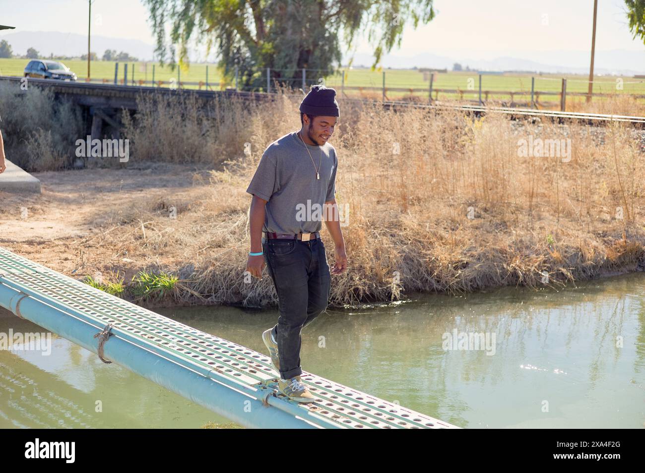 Man walks carefully across narrow metal walkway over canal hi-res stock ...