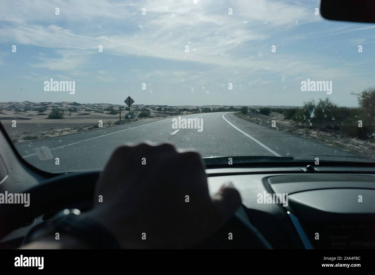 A first-person view from inside a vehicle showing a hand on the ...