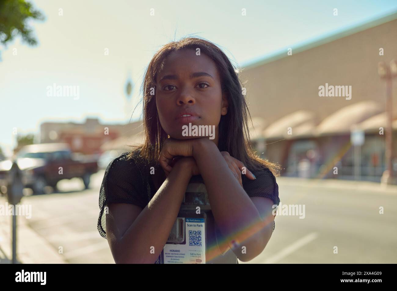 Woman rests chin hands atop parking meter sunny street hi-res stock ...