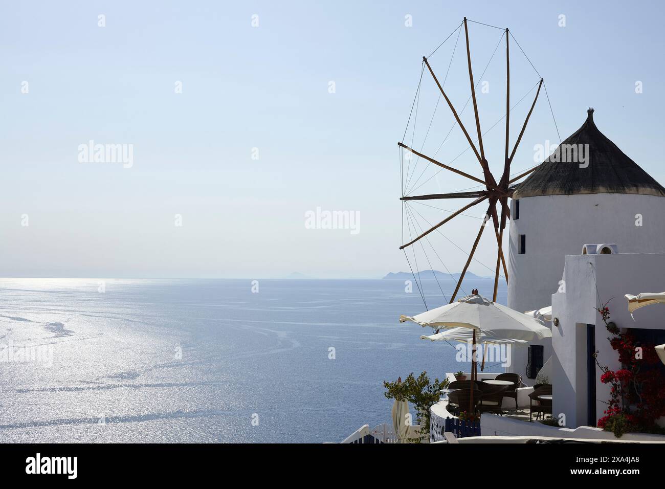 A traditional white windmill with a wooden windwheel overlooks the ...