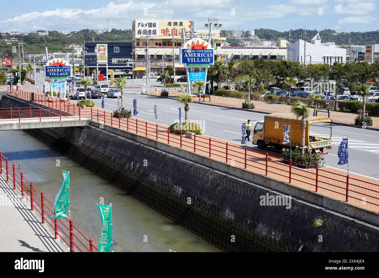 This is an outdoor image showing a canal with a red railing alongside ...