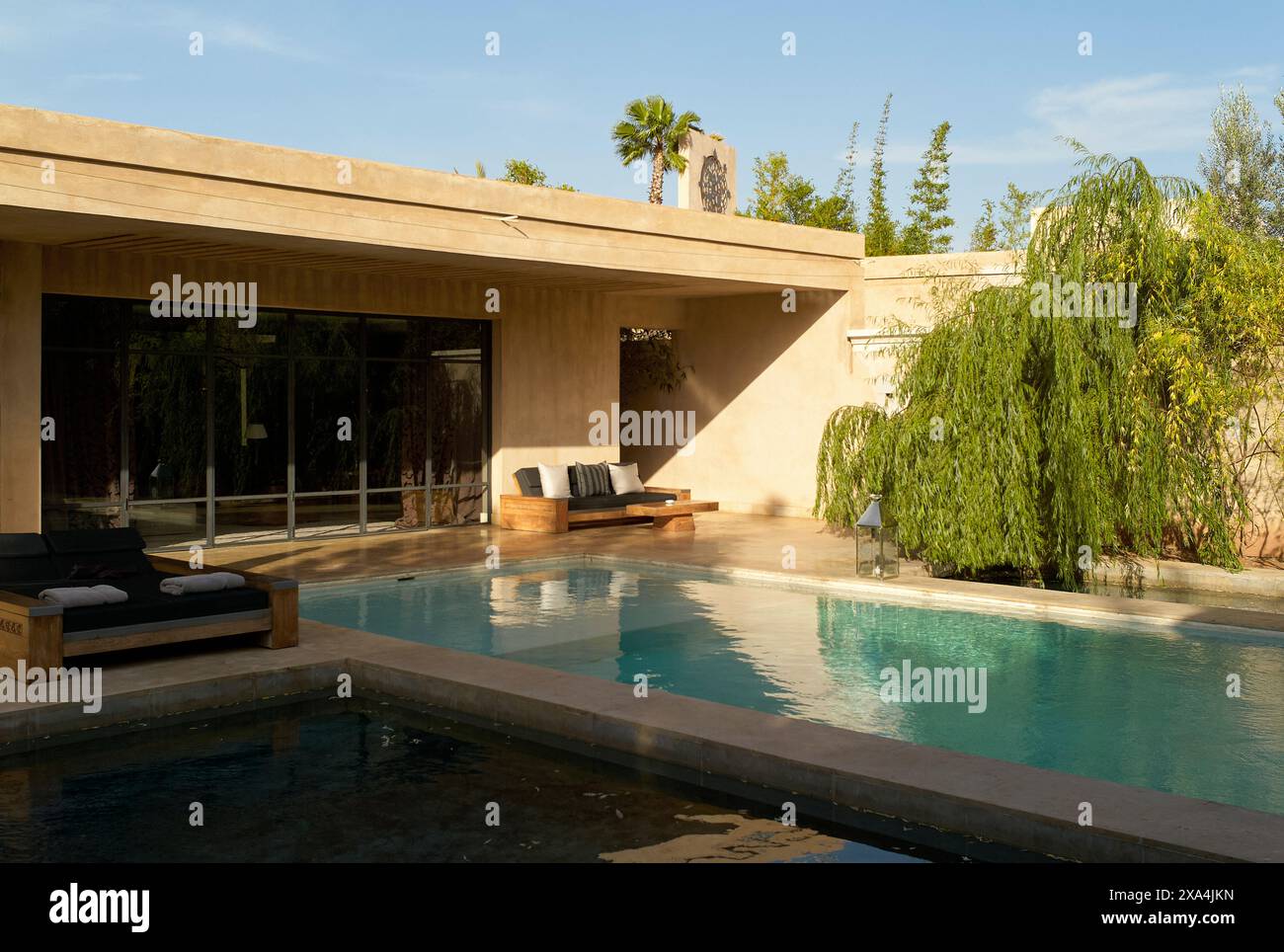 A modern house with large glass windows overlooks a serene swimming ...