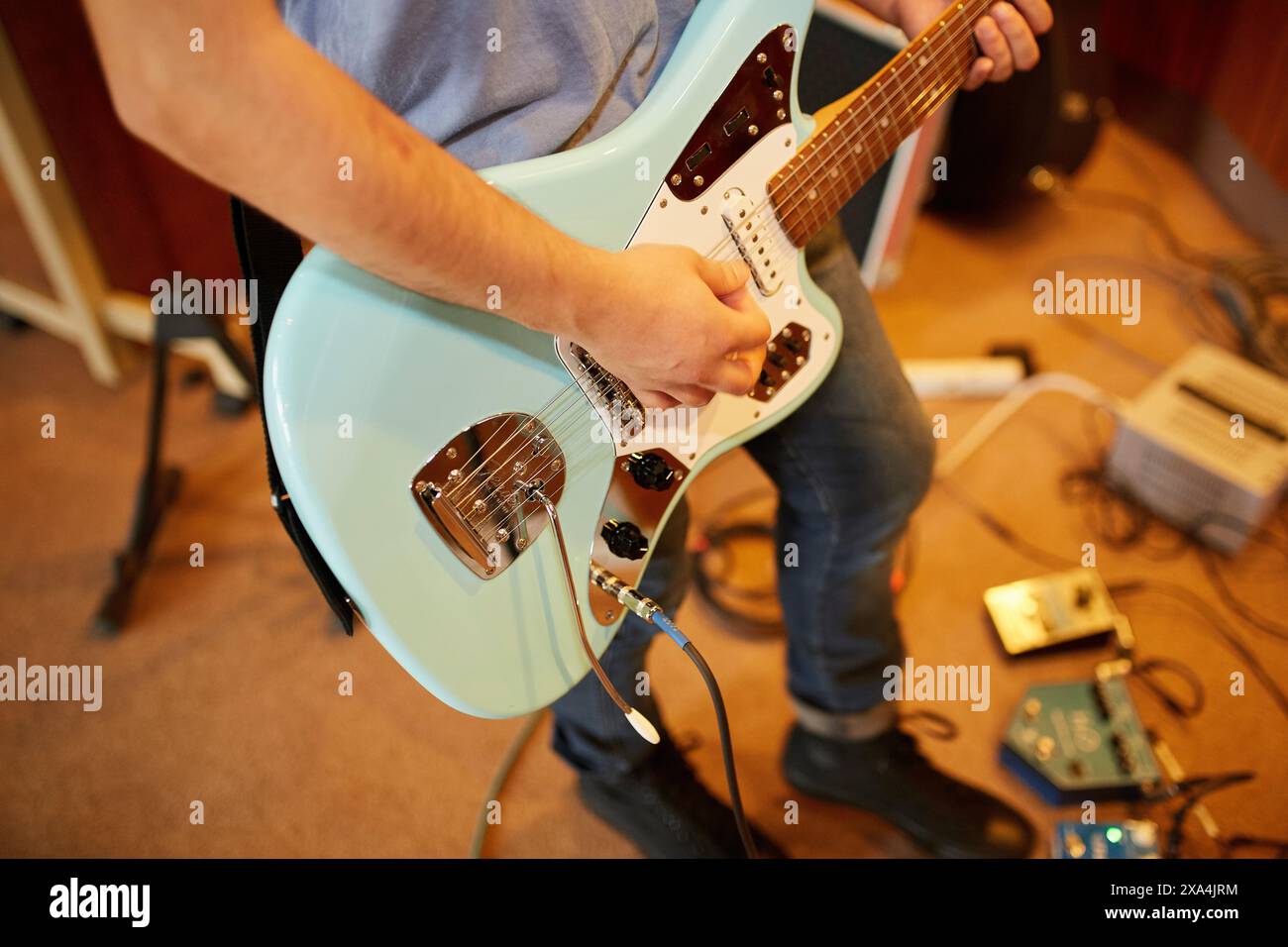 A Male band member is playing an electric guitar, focusing closely on ...