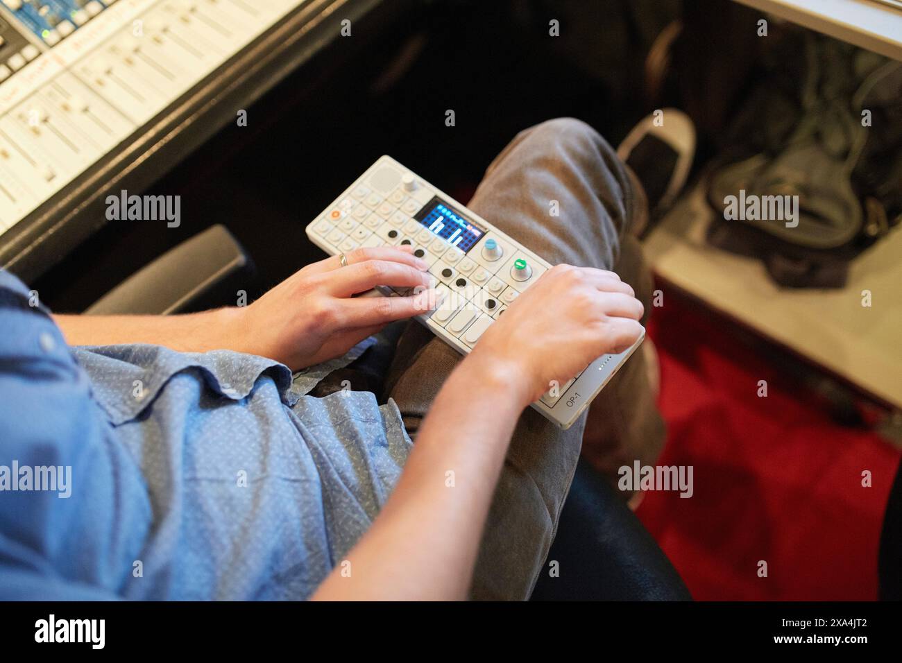 A person is operating an audio mixer, focusing on adjusting the ...
