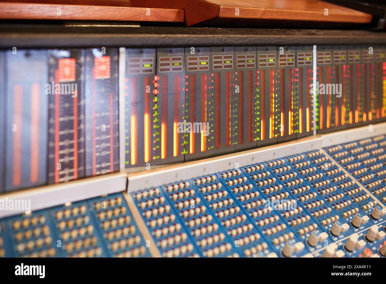 Close-up view of a professional audio mixing console with faders and ...
