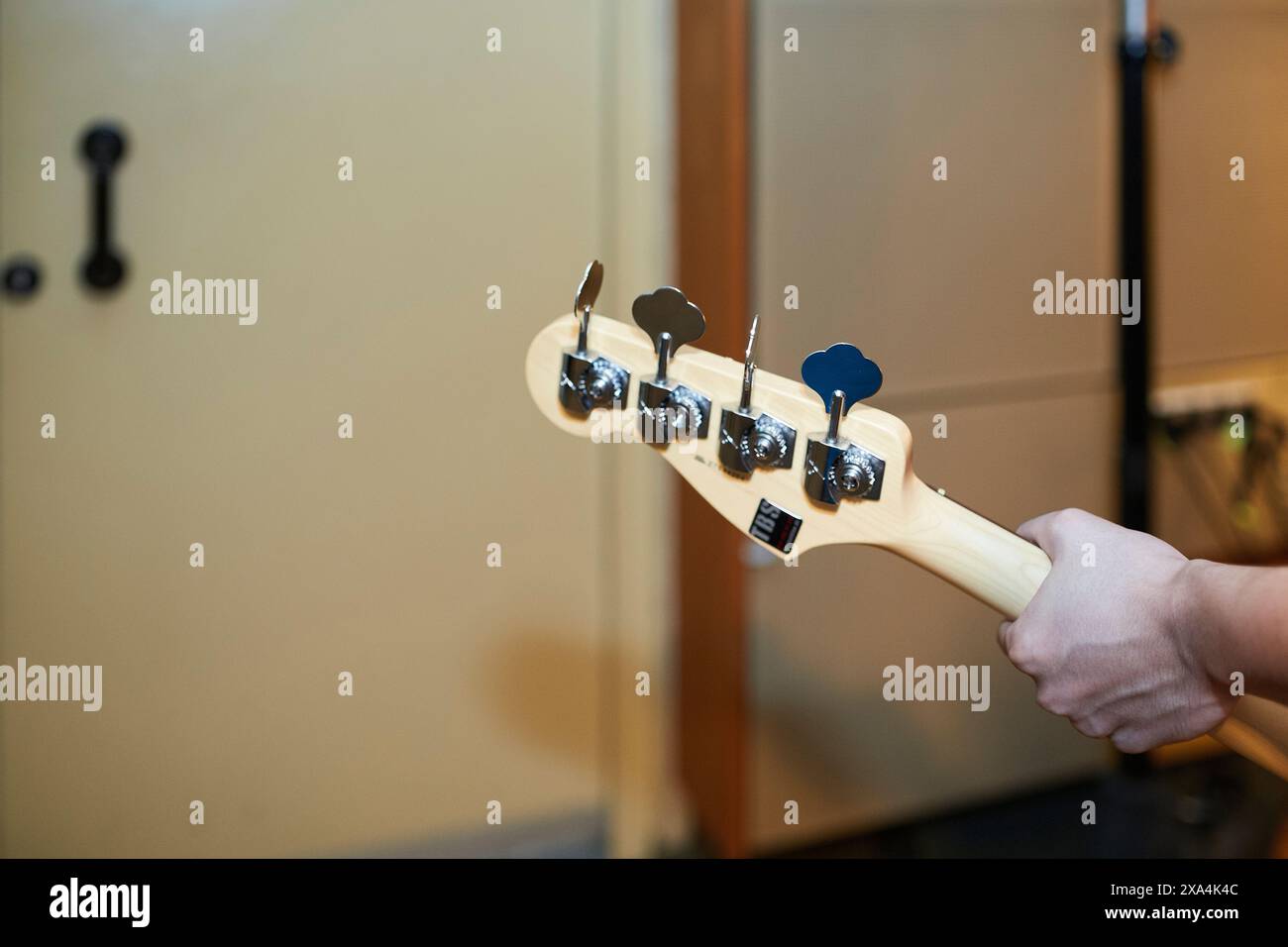 A close-up shot of a person's hand tuning the pegs on the headstock of ...