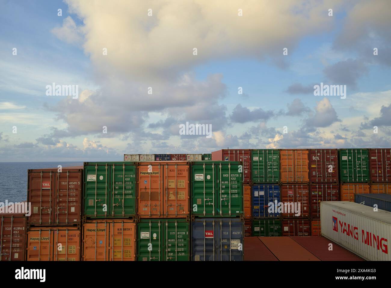 The image shows a stack of colorful shipping containers on a cargo ship ...