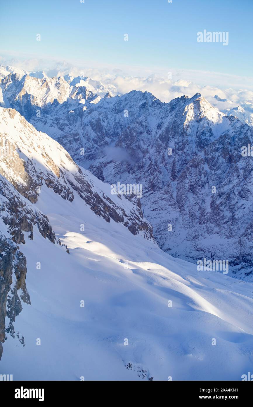 The image shows a majestic snowy mountain range with sharp peaks and a ...