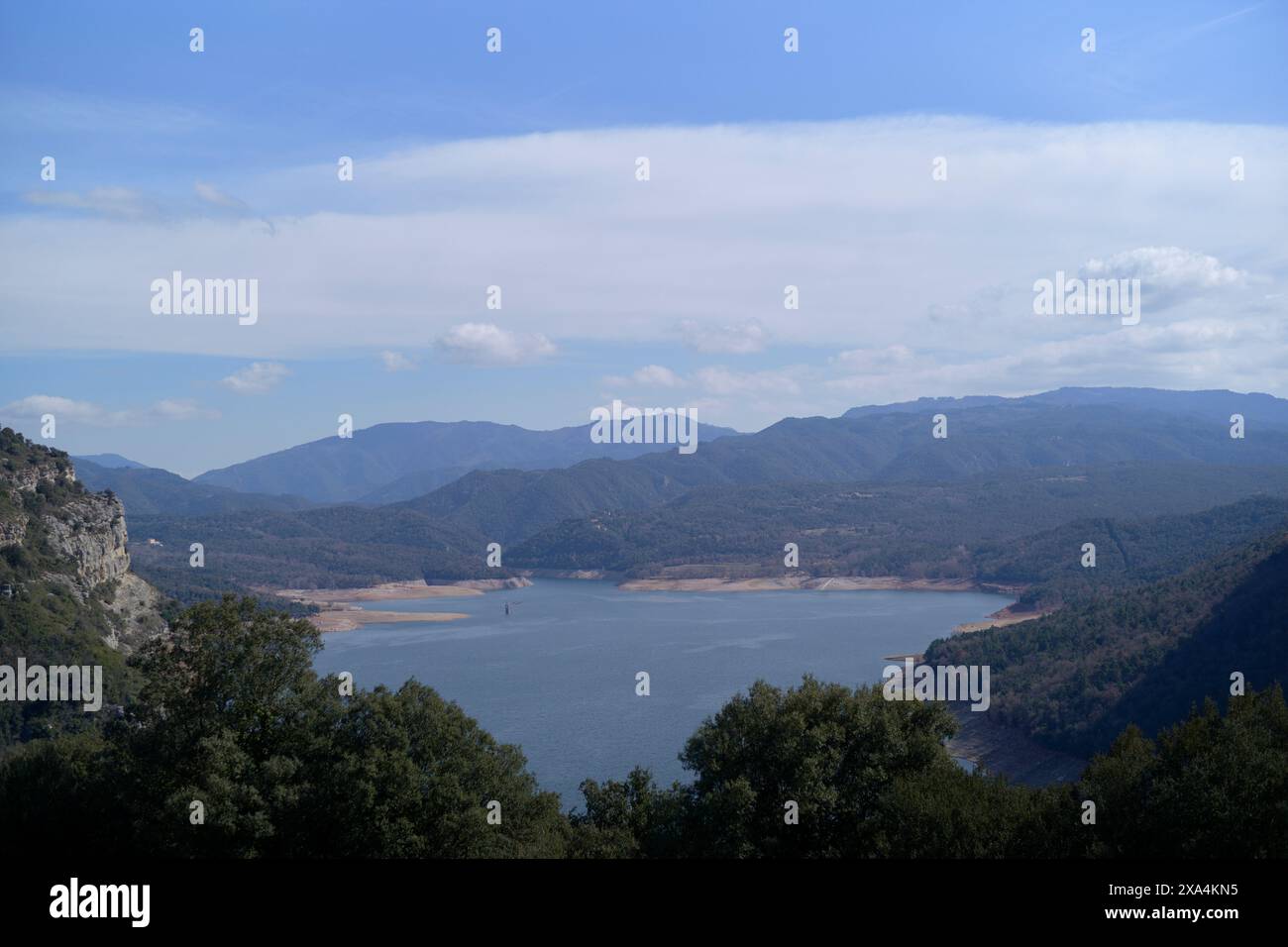 A scenic view overlooking a reservoir surrounded by mountains under a ...