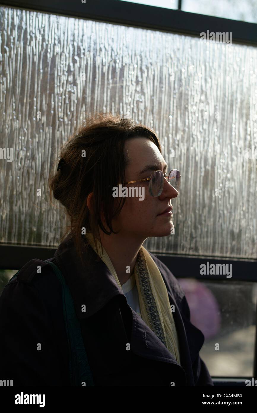 A person is profiled against a backdrop of a frosted glass window ...
